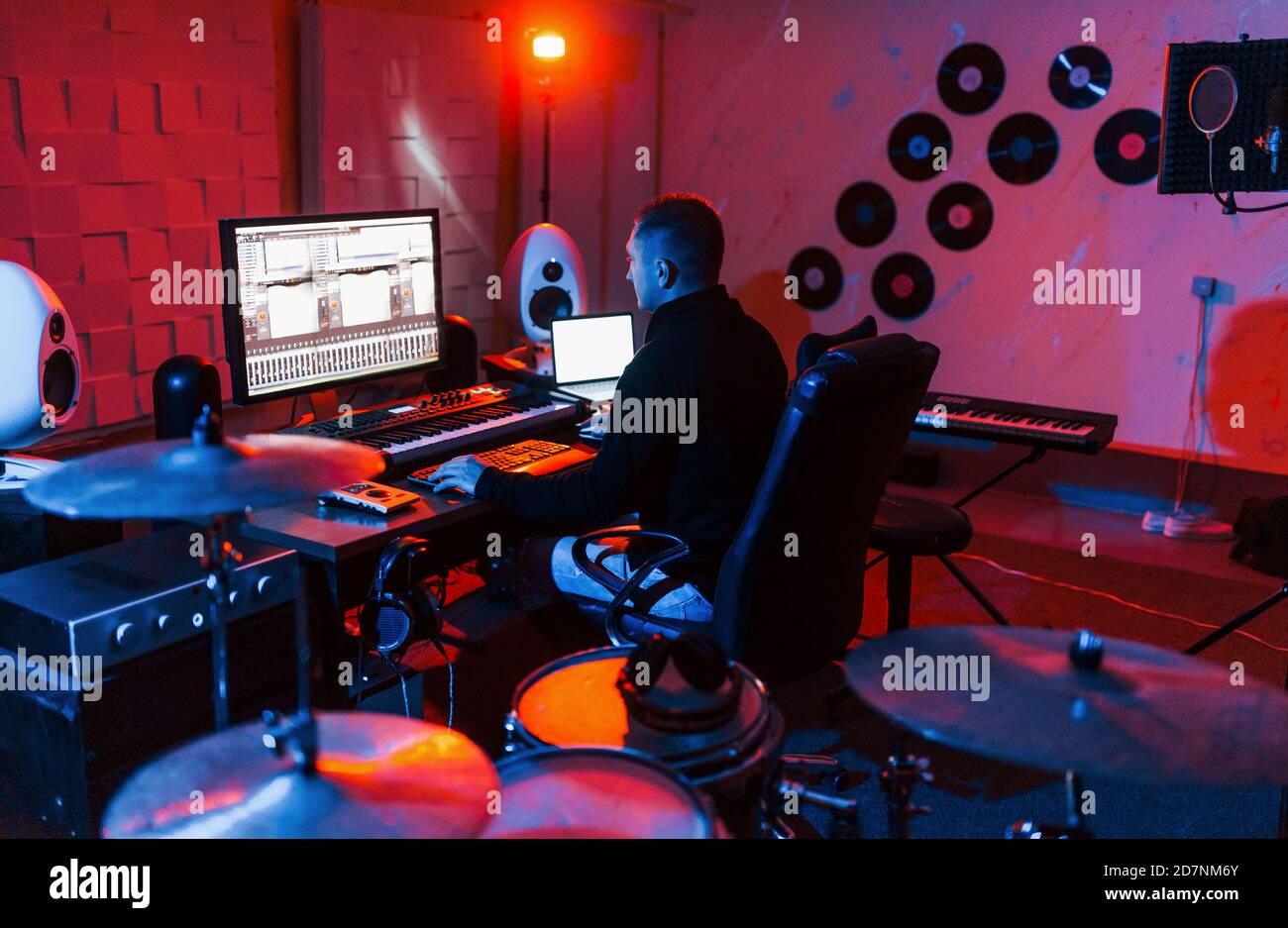 Sound engineer working and mixing music indoors in the studio near drum kit Stock Photo - Alamy