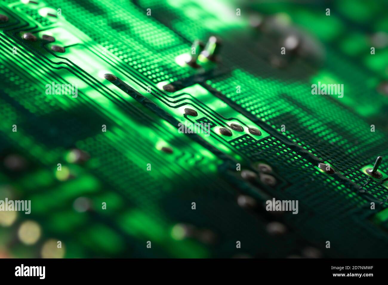 Illuminated fresh green electronic circuit board with many electrical ...