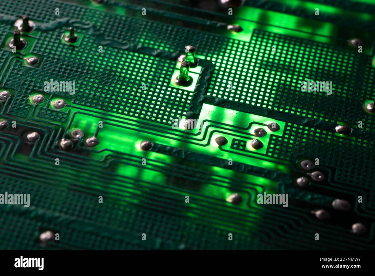 Illuminated fresh green electronic circuit board with many electrical ...