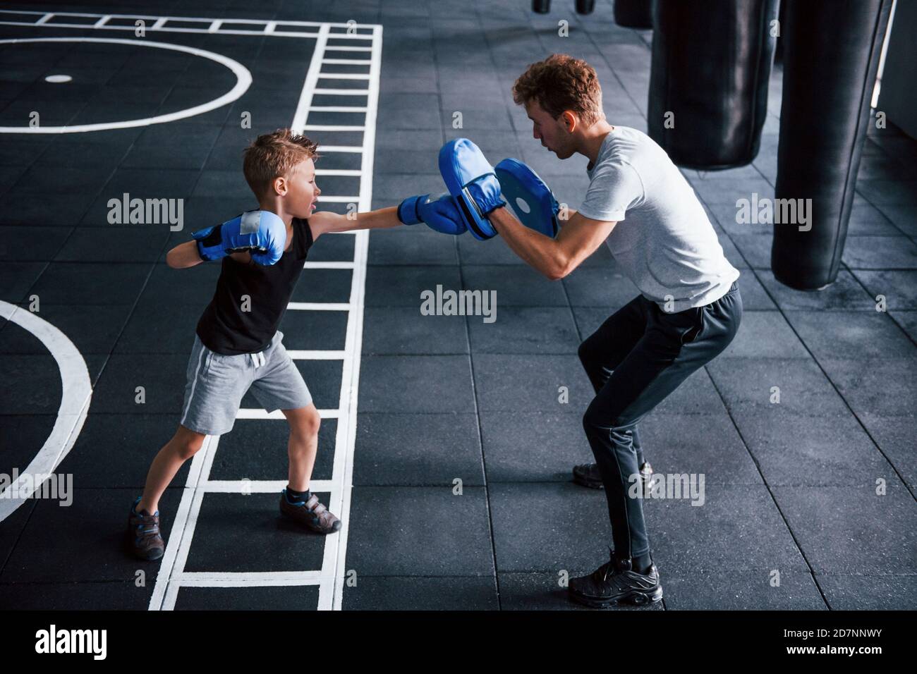 Young trainer teaches kid boxing sport in the gym Stock Photo - Alamy