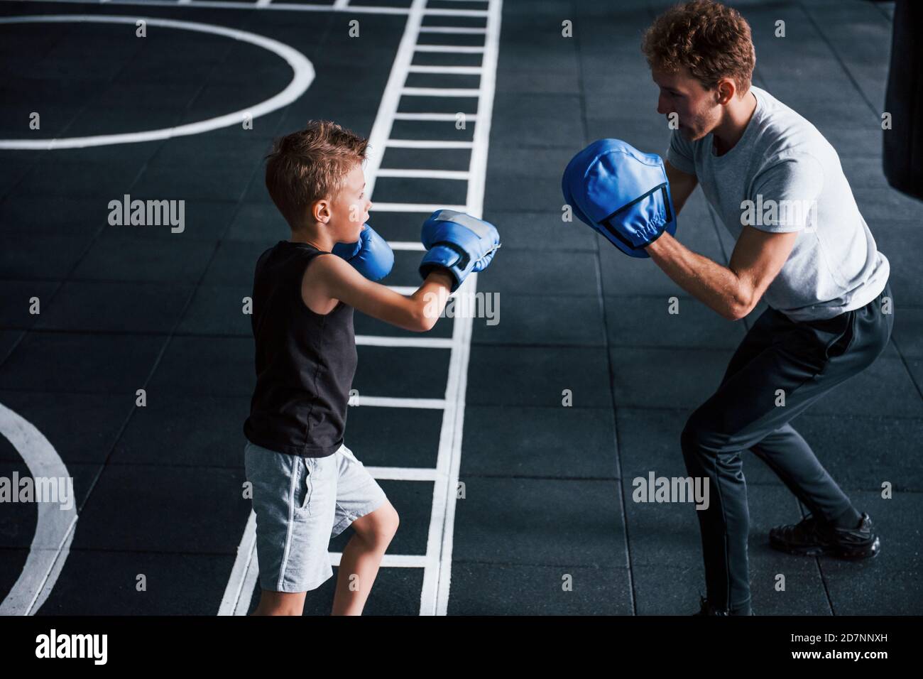 Young trainer teaches kid boxing sport in the gym Stock Photo - Alamy