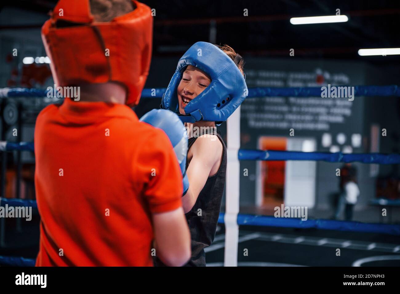 Two boys in protective equipment have sparring and fighting on the ...