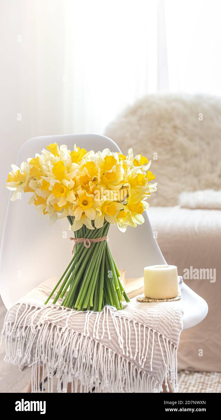 Composition with spring flowers in a cozy living room interior . The ...