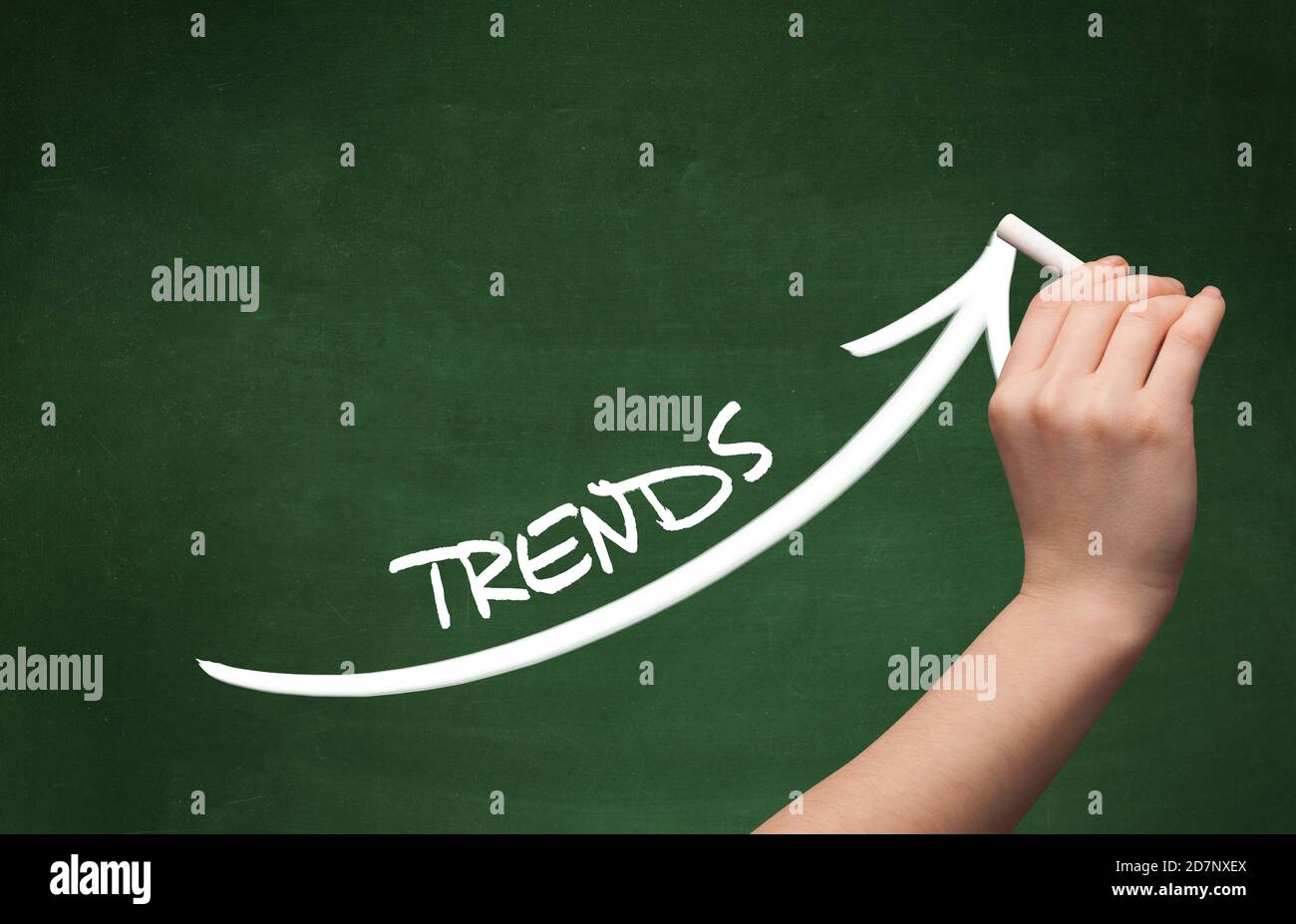 Hand drawing TRENDS inscription with white chalk on blackboard ...