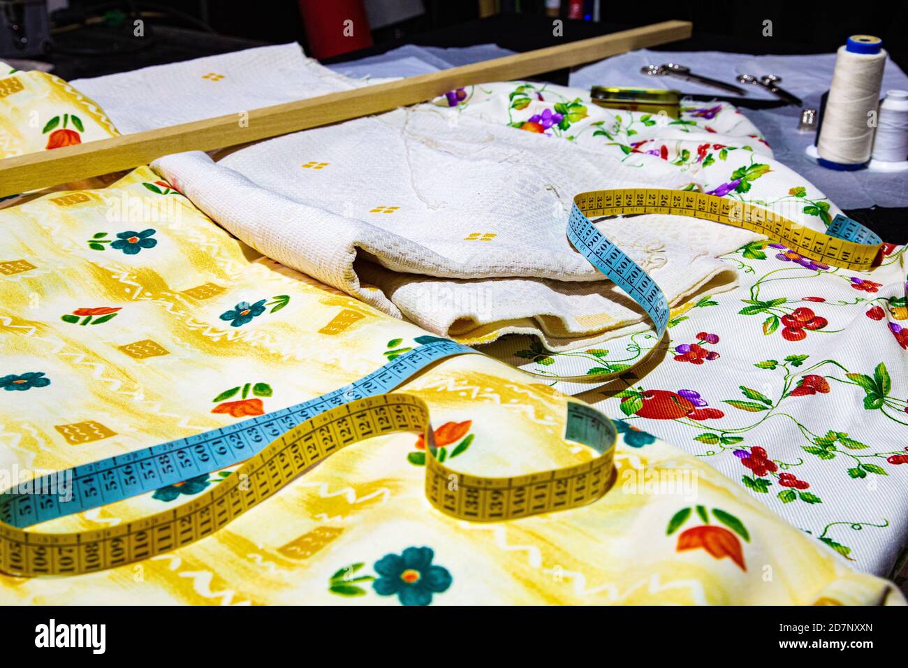 Yellow toned fabrics with patterned details and sewing accessories ...