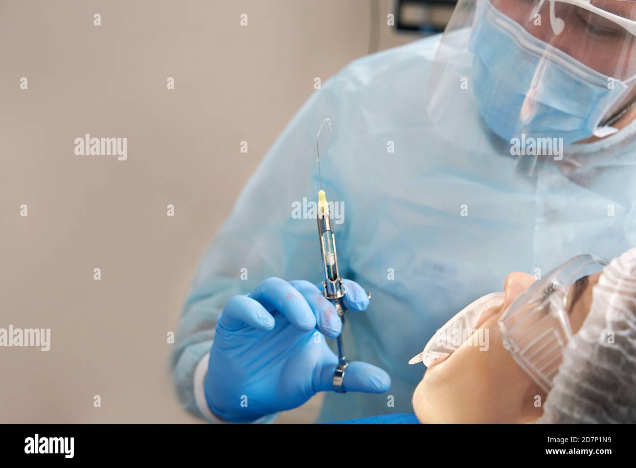 Dentist making local anesthesia shot before surgery. Patient visiting a ...