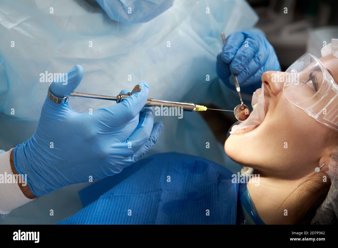 Dentist making local anesthesia shot before surgery. Patient visiting a ...