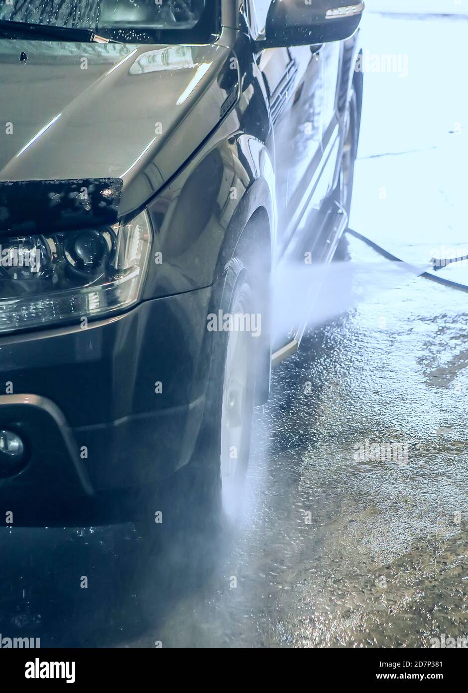car under streams of water in a car wash. Front view Stock Photo - Alamy