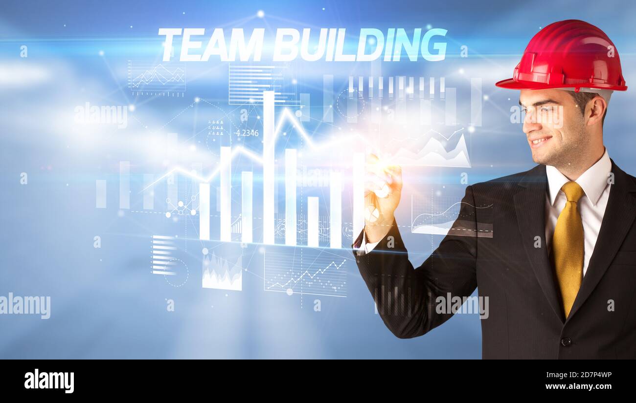 Handsome businessman with helmet drawing TEAM BUILDING inscription ...