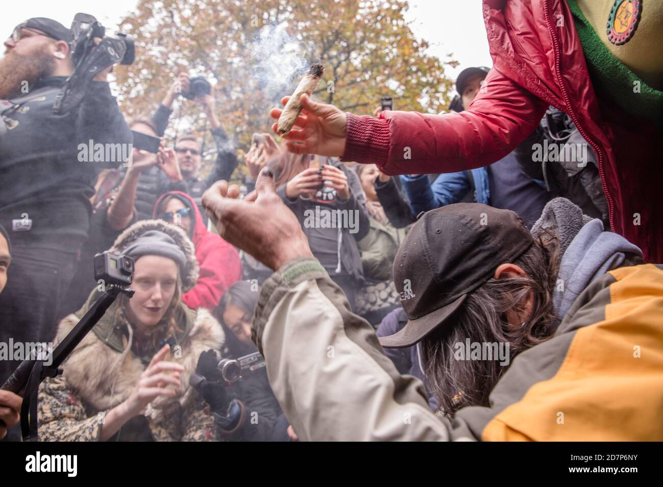 A man passing a big joint to another person during the cannabis ...