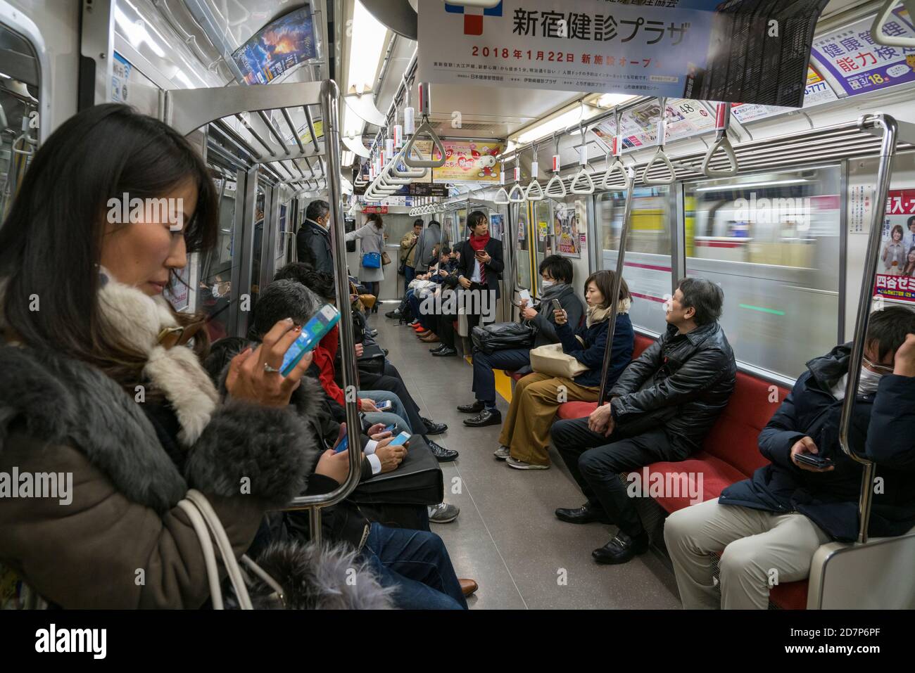 Commuters ride on the Toei Oedo Line on late Friday night at Tokyo ...