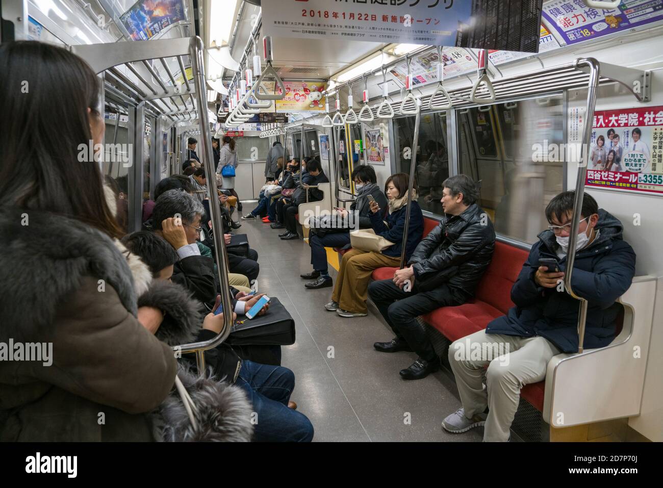 Commuters ride on the Toei Oedo Line on late Friday night at Tokyo ...