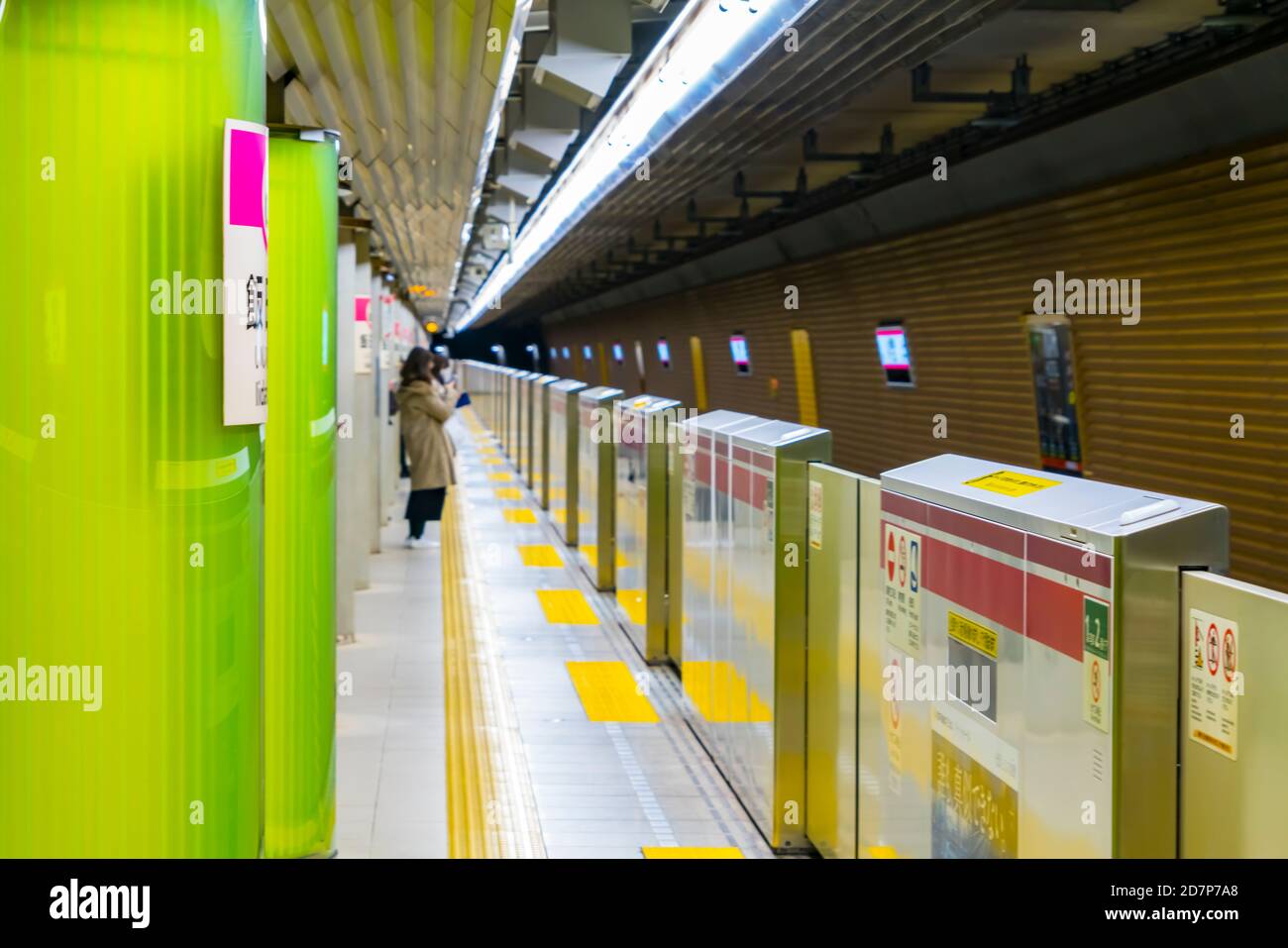 Commuters wait to get on the Toei Oedo Line at Iidabashi Station Tokyo ...