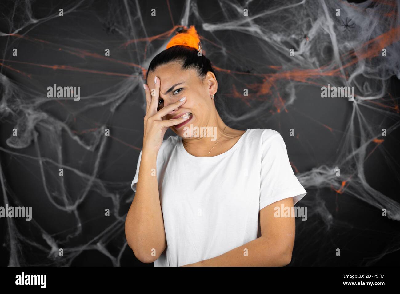 Young beautiful woman over black background with cobwebs and spiders ...