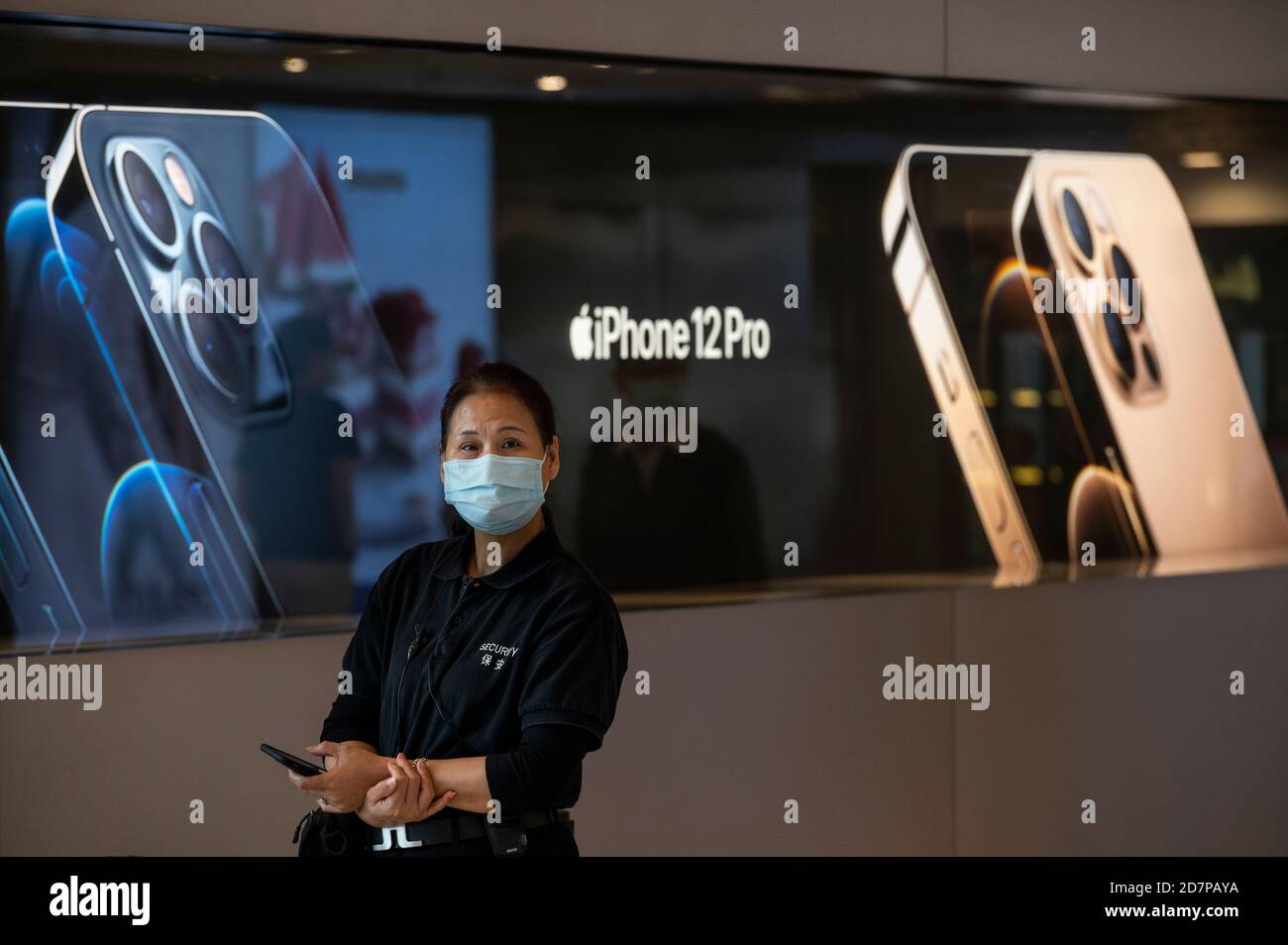 An Apple security guard wearing a face mask stands at the American ...