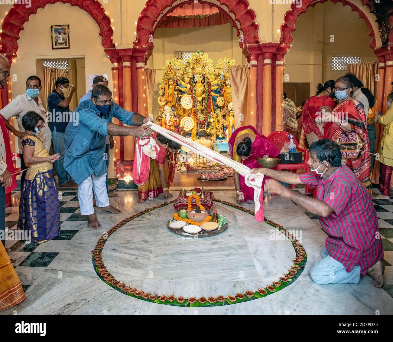 Kolkata, India. 24th Oct, 2020. Priest and family members of an old ...