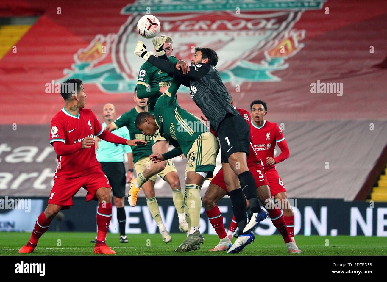 Liverpool goalkeeper Alisson punches clear under pressure from ...