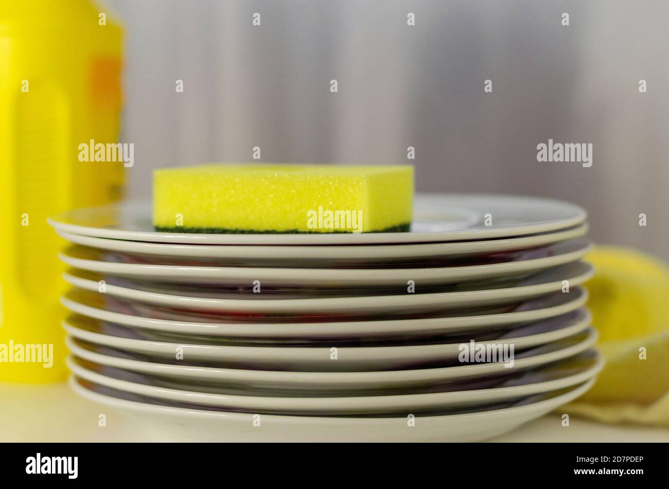 Bottle of dishwashing liquid and stack of utensils isolated on white ...