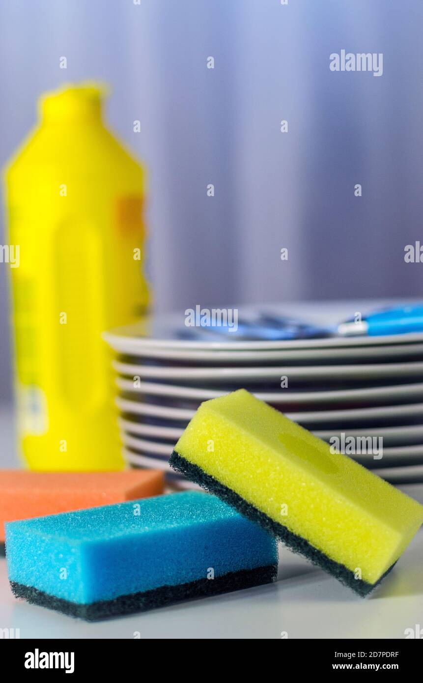 Bottle of dishwashing liquid and stack of utensils isolated on white ...