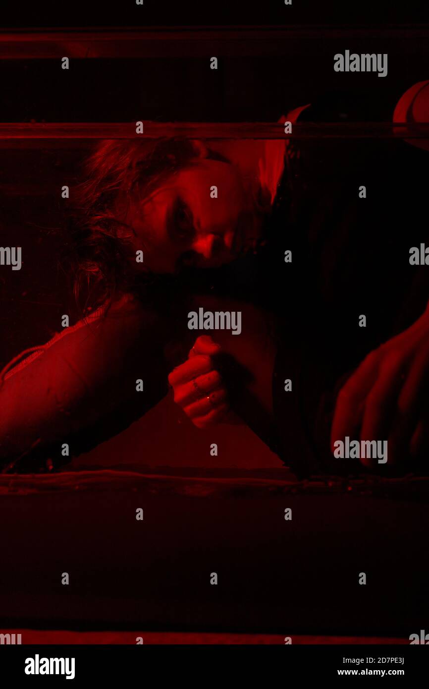 Horrible portrait of a young girl in a horror room with a red light ...