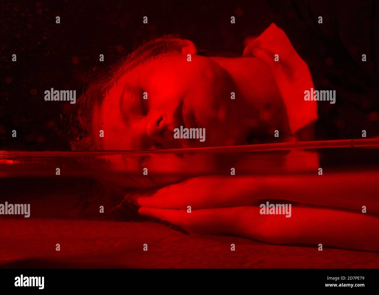 Horrible portrait of a young girl in a horror room with a red light ...
