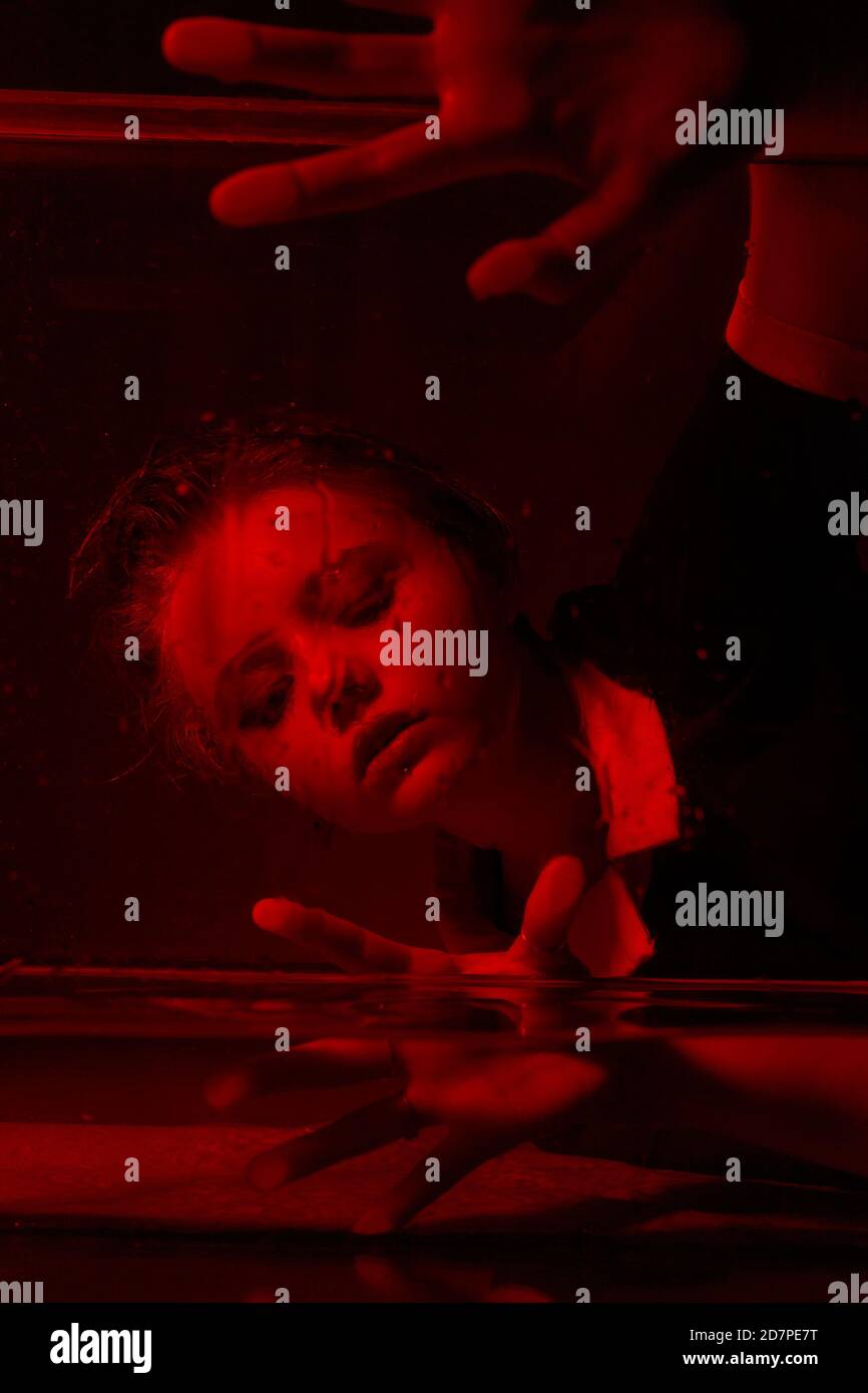 Horrible portrait of a young girl in a horror room with a red light ...