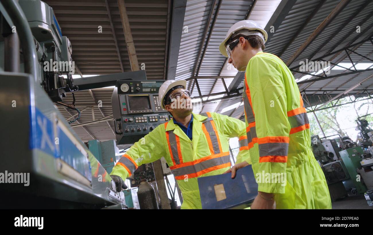Group of factory workers using machine equipment in factory workshop ...