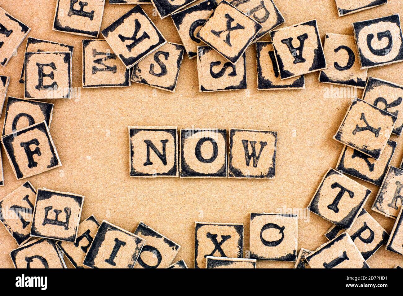 Word Now spelled out from cardboard letters made by black alphabet ...