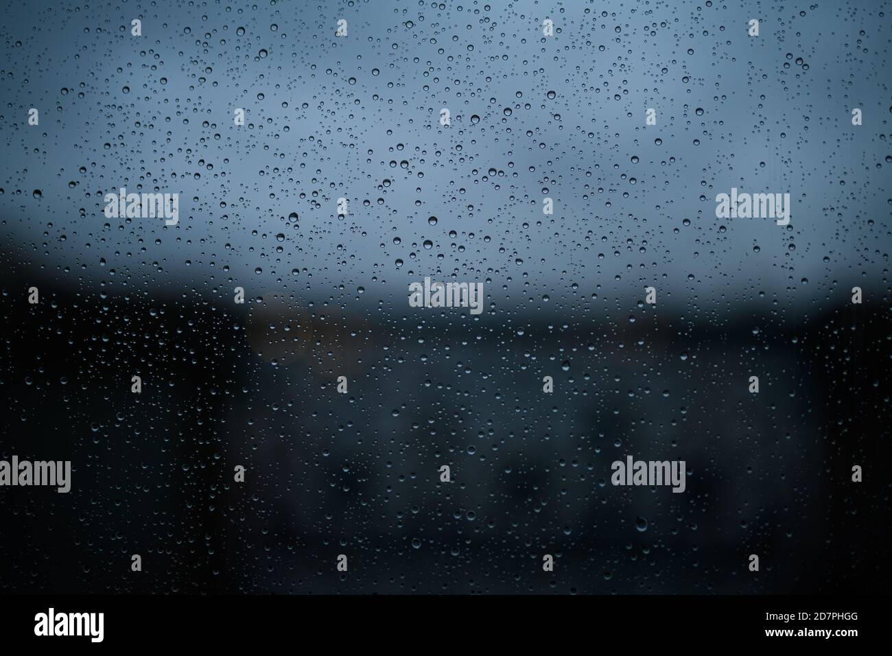 Rain drops on window glass surface with city background . Natural ...