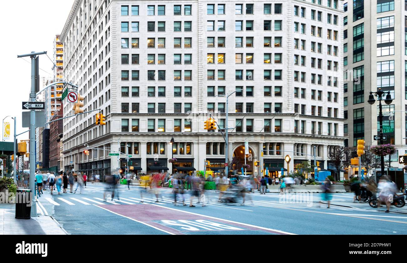 Crowds of people in motion walking across the busy intersection of 23rd ...