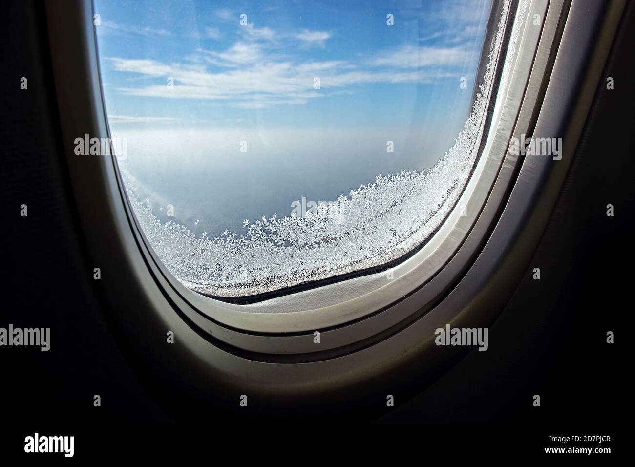 frozen ice on airplane window with blue sky Stock Photo - Alamy