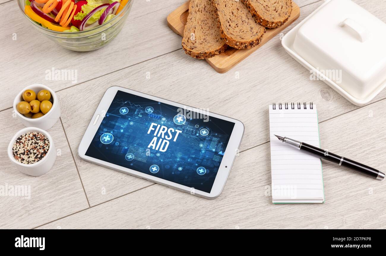 FIRST AID concept in tablet pc with healthy food around, top view Stock ...