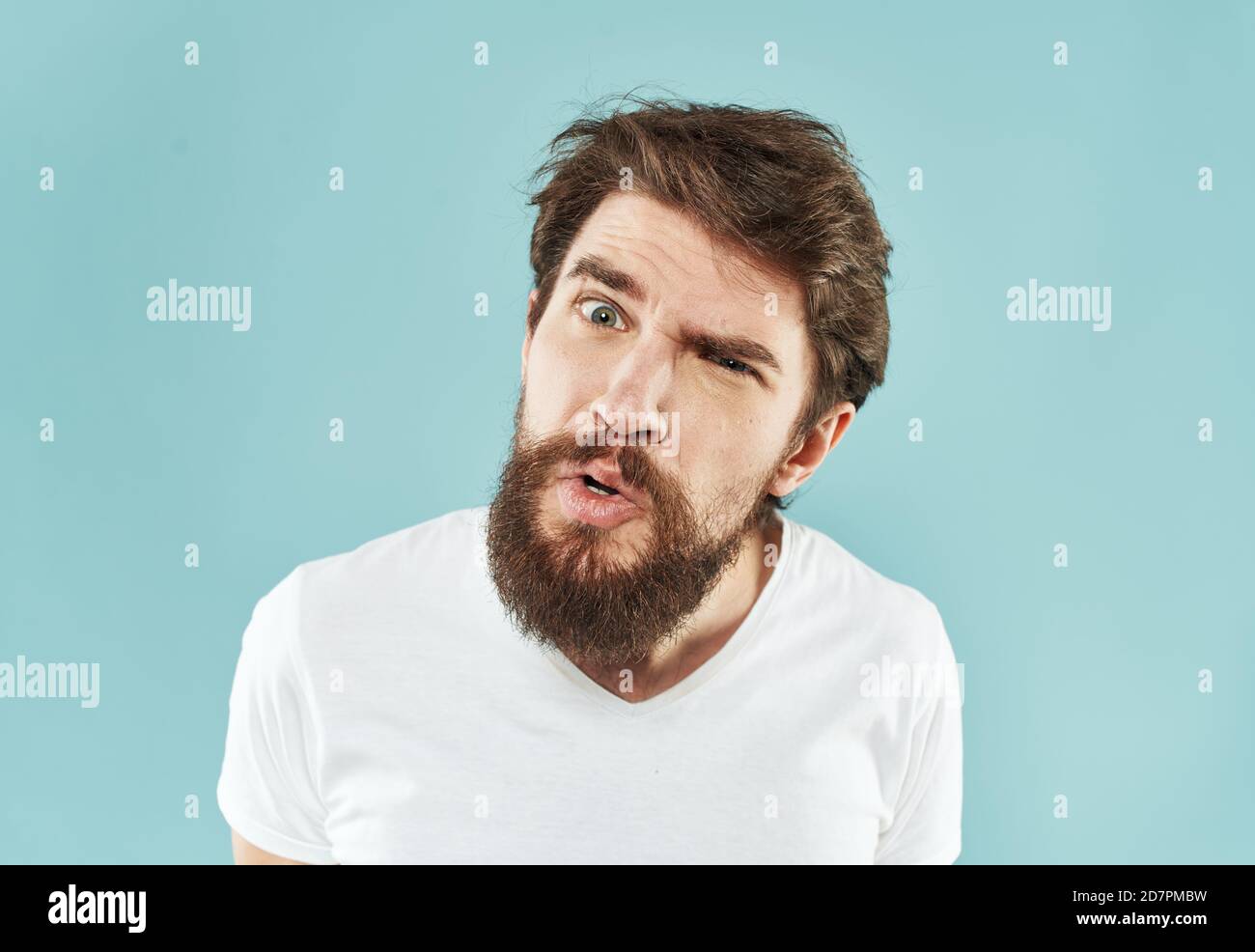 Aggressive man with a beard on a blue background cropped view Stock ...