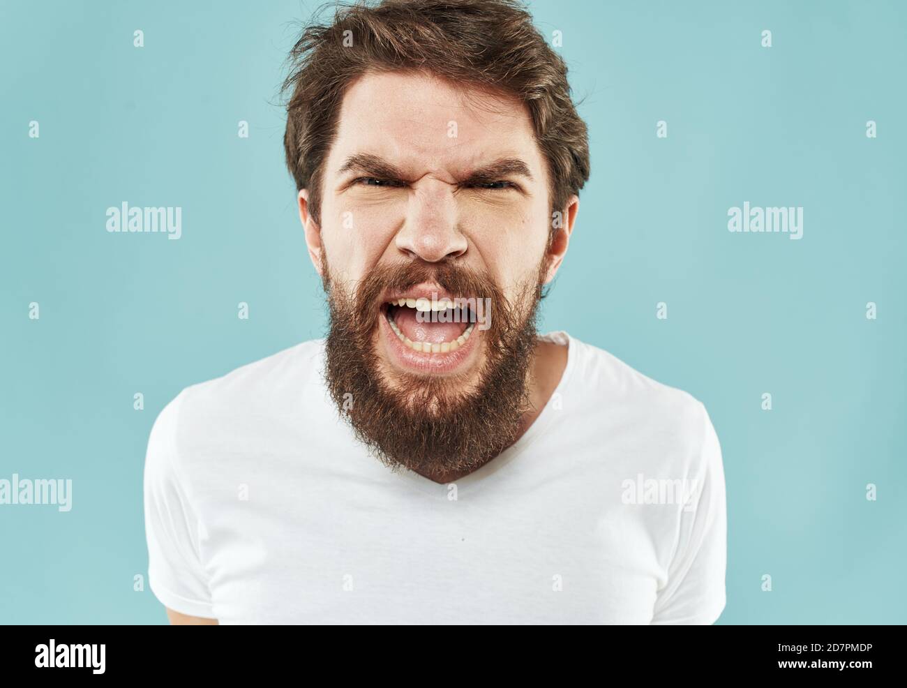 Aggressive man with a beard on a blue background cropped view Stock ...