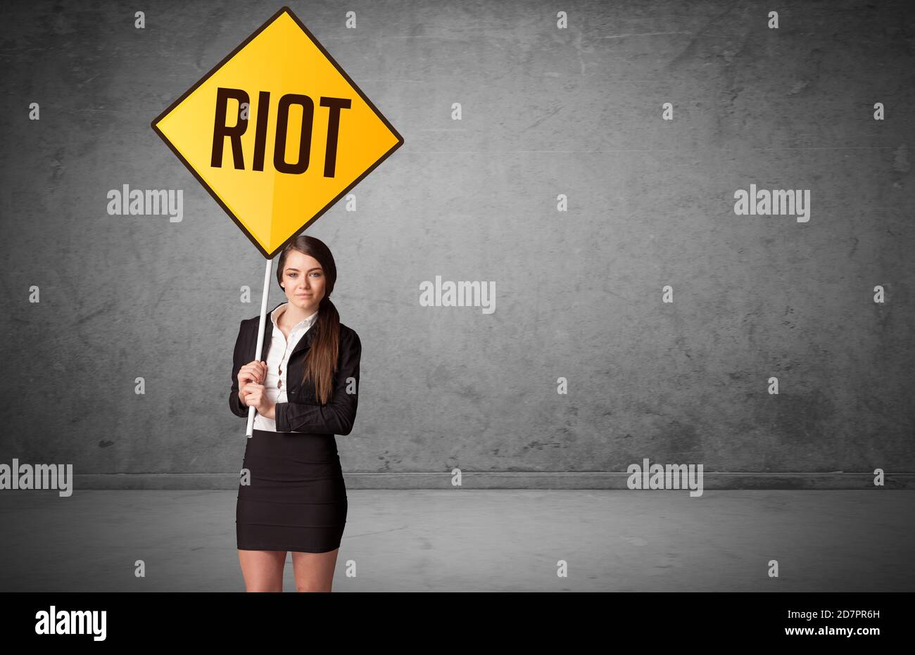 Young business person holding road sign with RIOT inscription, new ...
