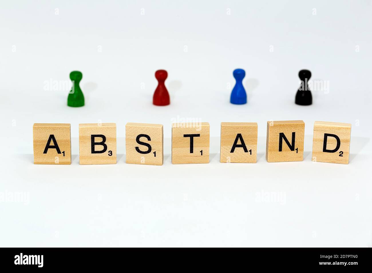 Letter blocks form the word "Abstand" (distance), behind them colourful ...