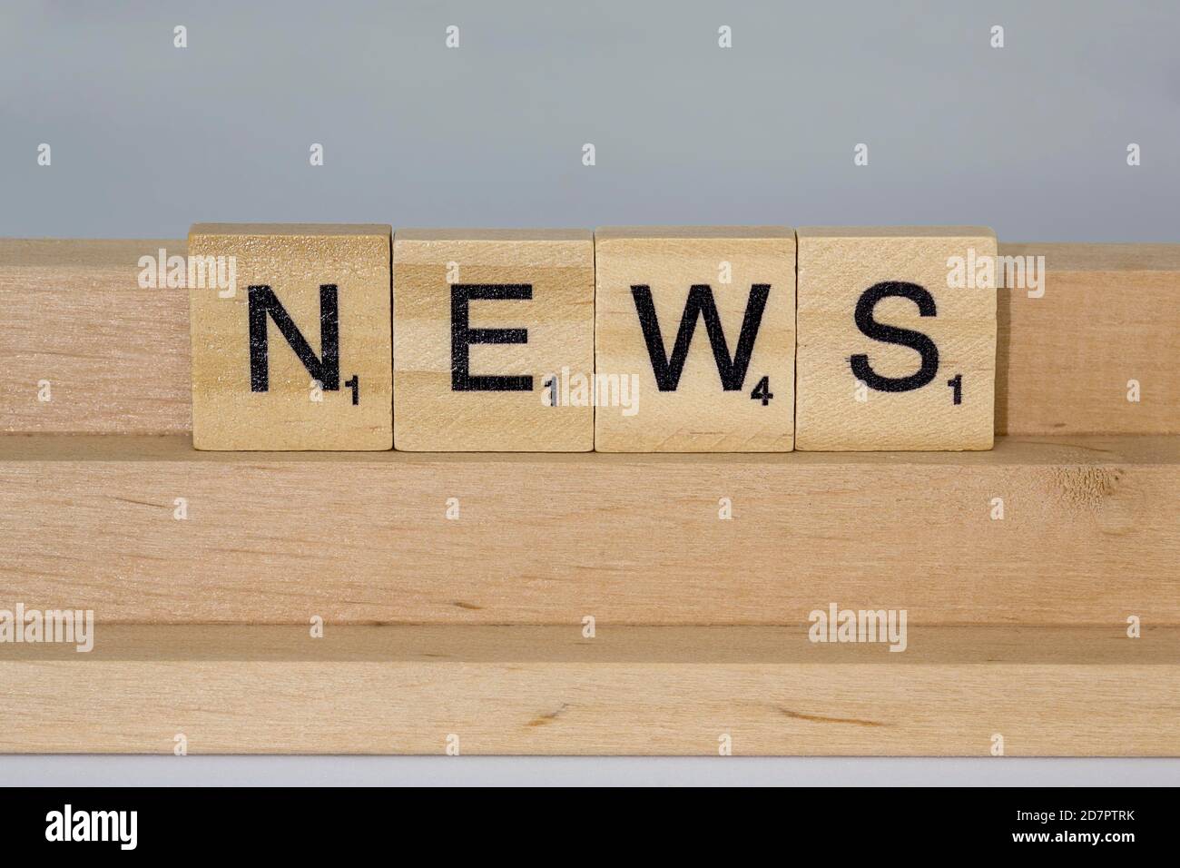 Letter blocks on a wooden bar form the word News, symbol image for news ...