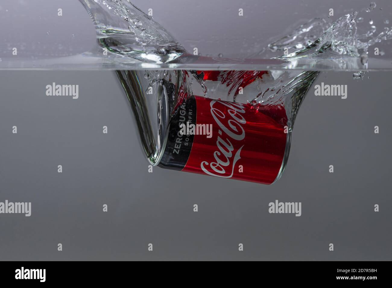 Close up view of coca cola falling in water on gray background ...