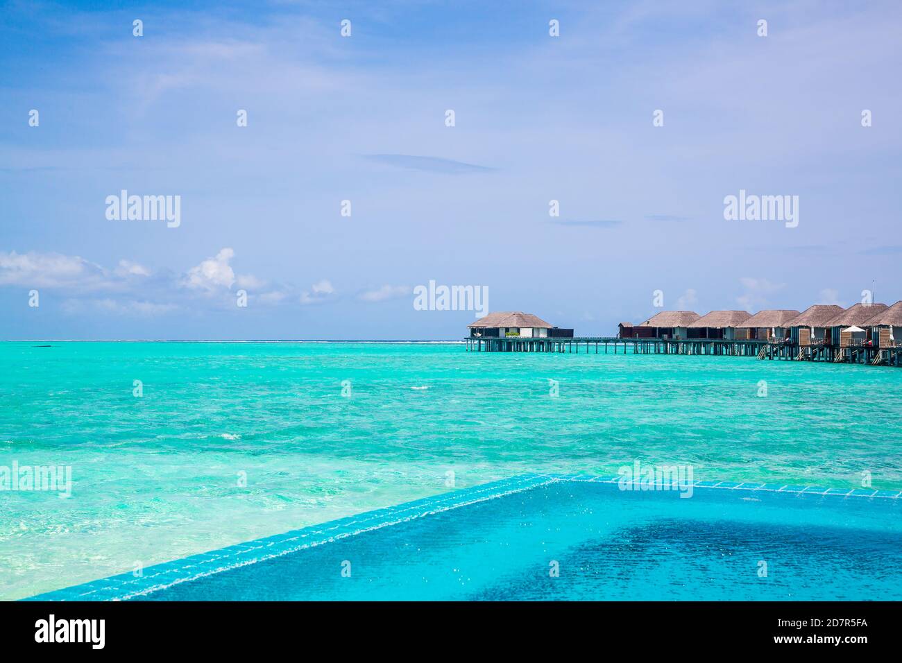 Long empty jetty in the Maldives with coral reefs in the water Stock ...