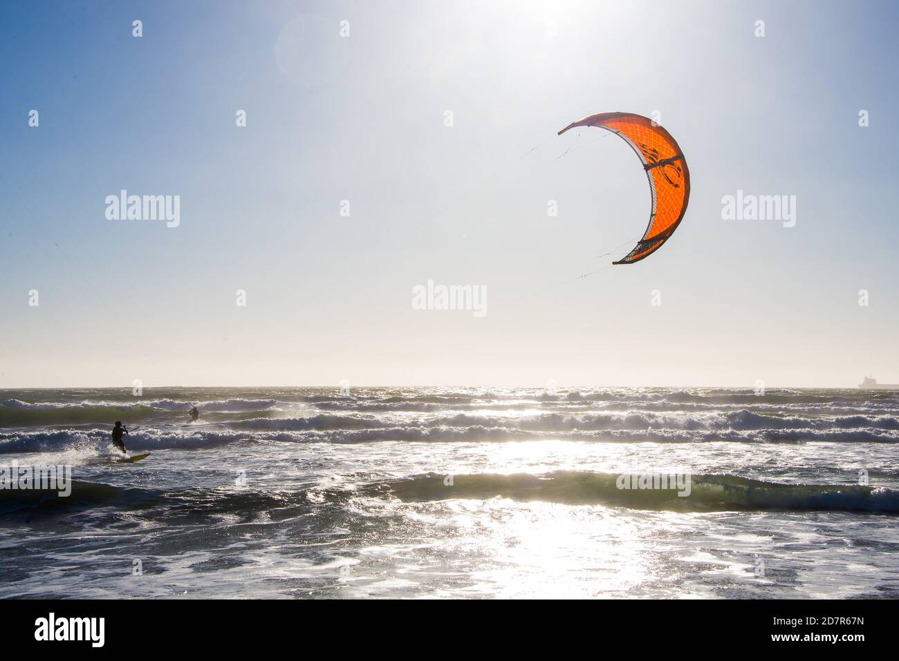 People kitesurfing on the wavy ocean gleaming under the sunrays Stock ...