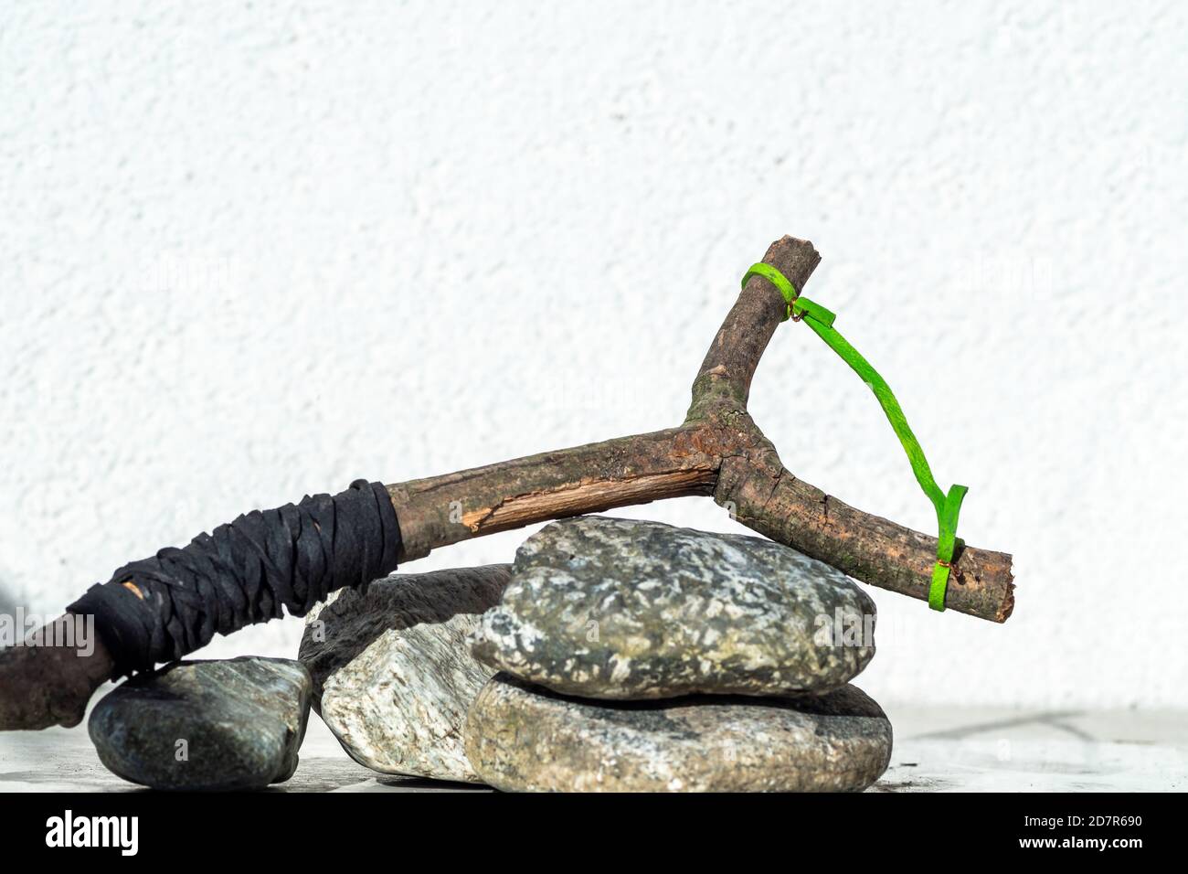 Wooden slingshot on a stone on a white background Stock Photo - Alamy