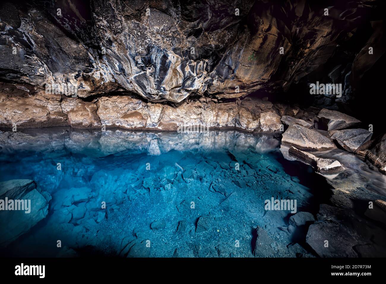 Inside of dark Grjotagja lava cave near lake Myvatn with hot springs ...