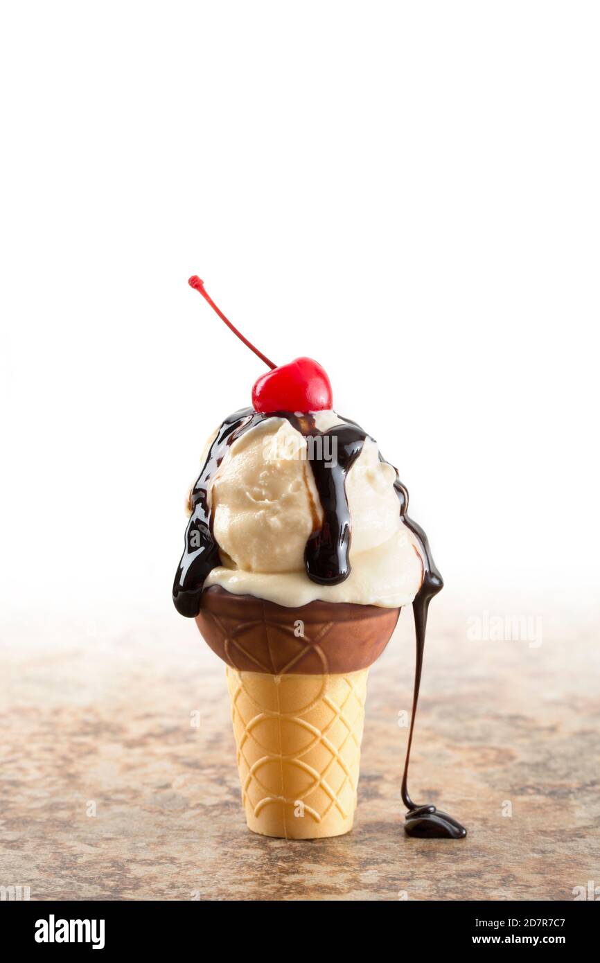 Messy ice cream cone with vanilla ice cream, chocolate syrup, and a ...