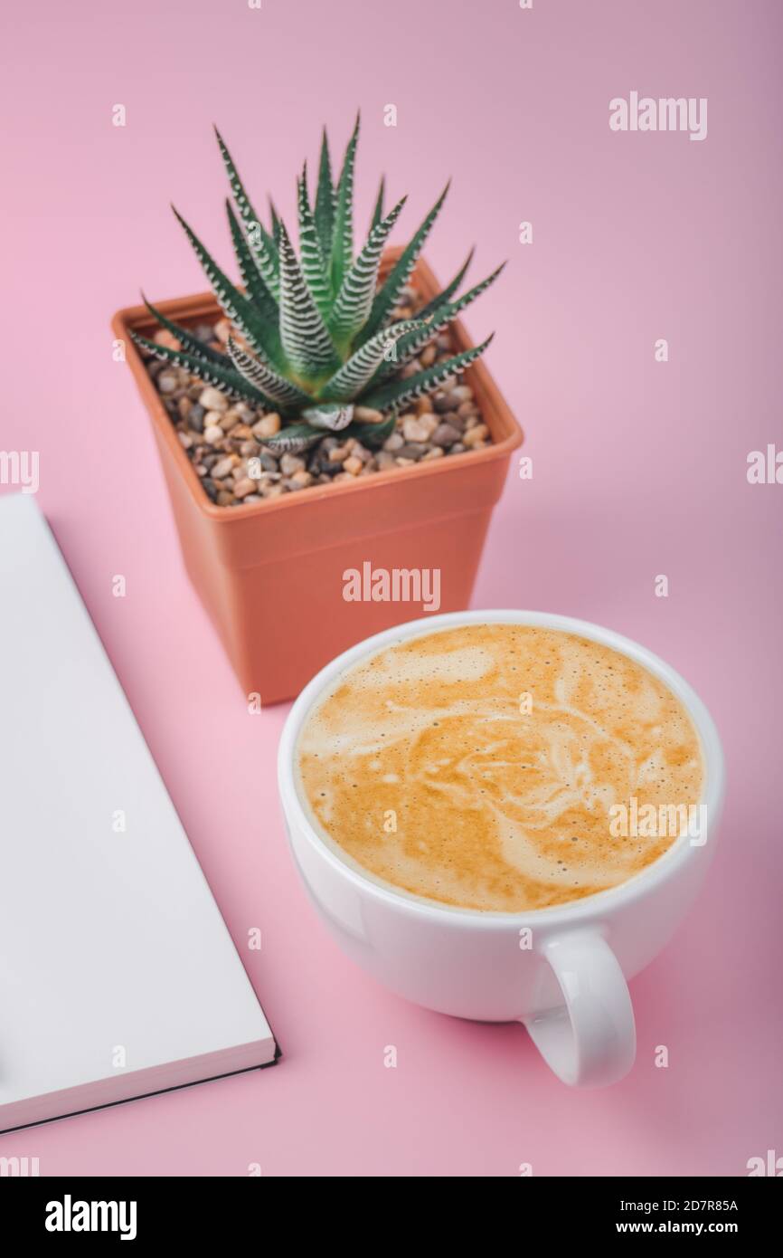 Close up cup of latte coffee on pink office desk table. morning life at ...