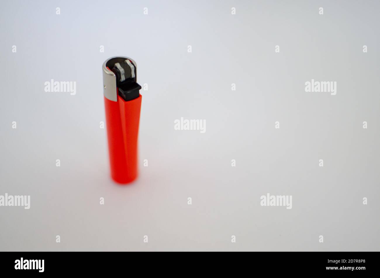 Small red lighter on a white background Stock Photo - Alamy