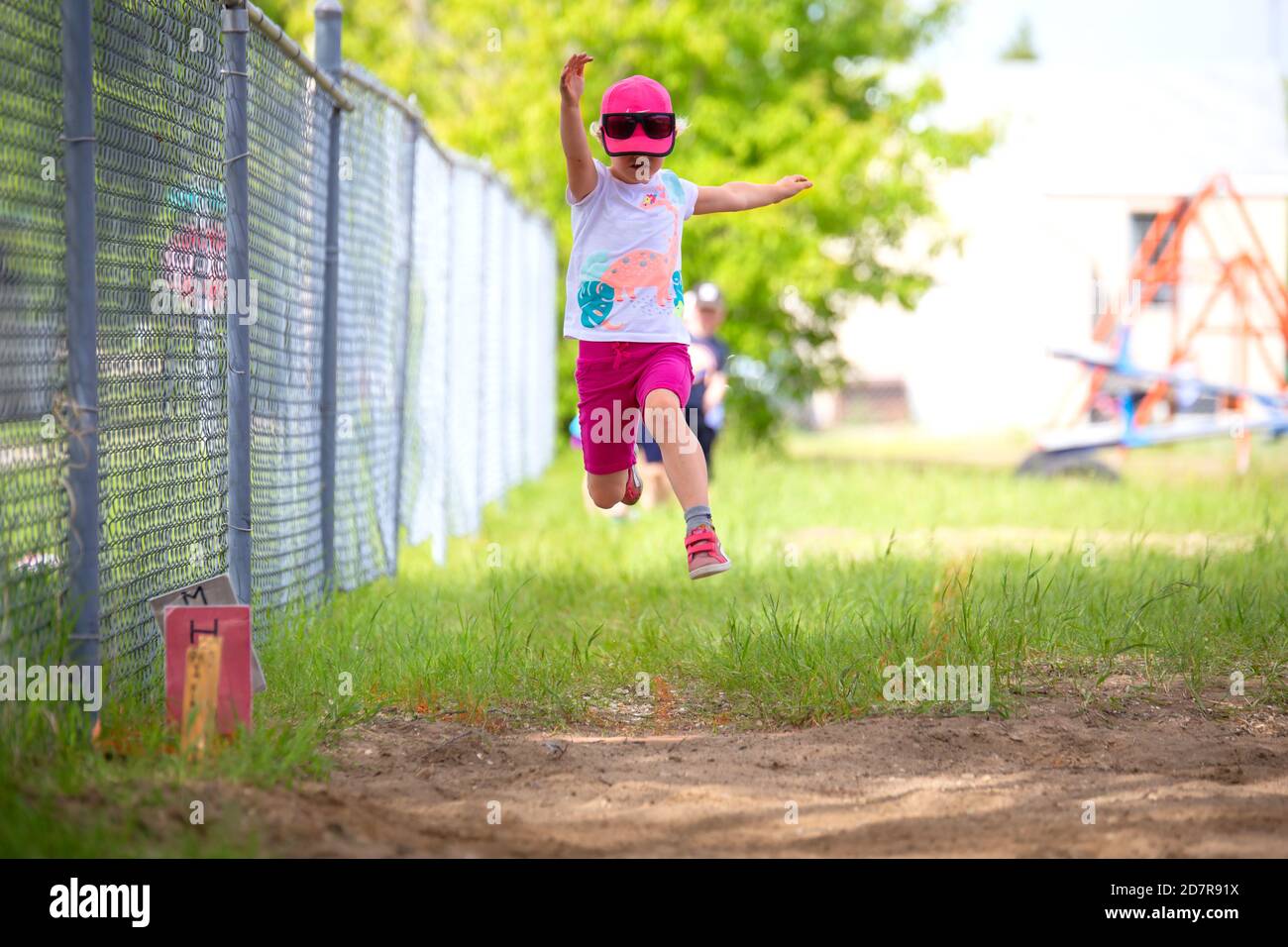 A seven year old girl leaping through the air at a school activity in ...
