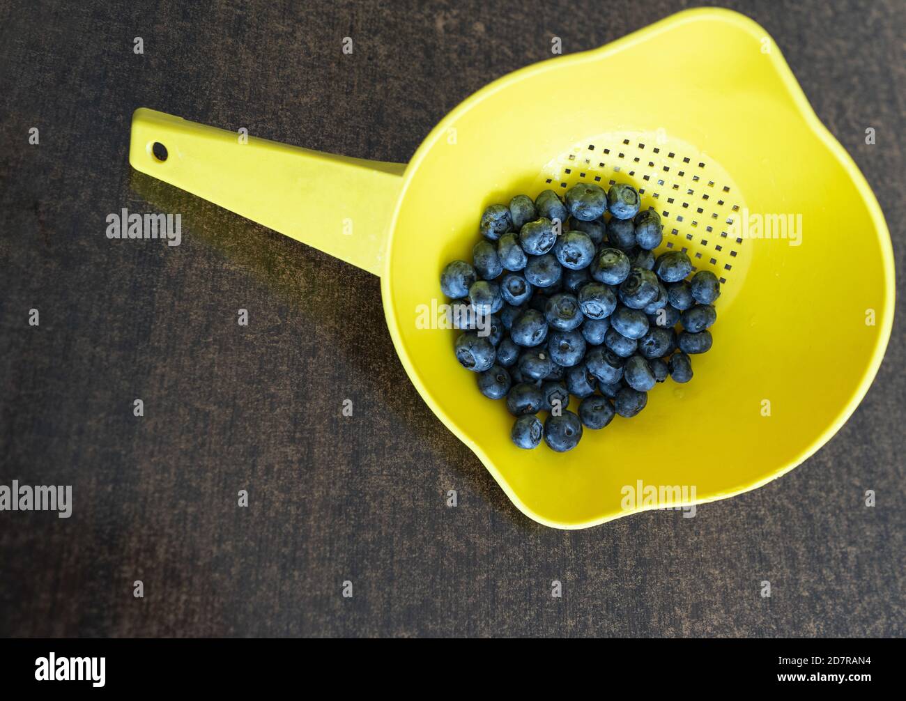 Closeup shot of fresh blueberries in a yellow colander Stock Photo - Alamy