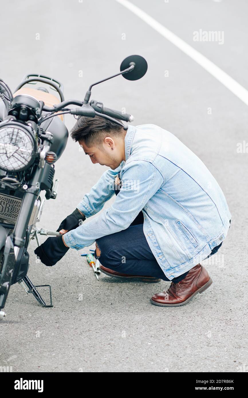 Man inspecting motorcycle Stock Photo - Alamy