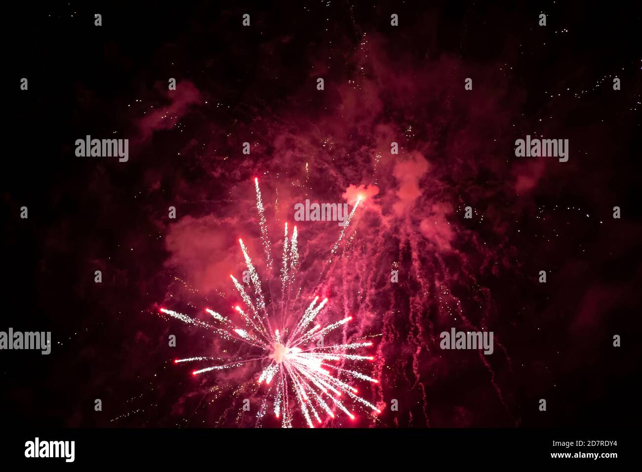 Red explosion of fireworks with smoke and bokeh on a black background ...