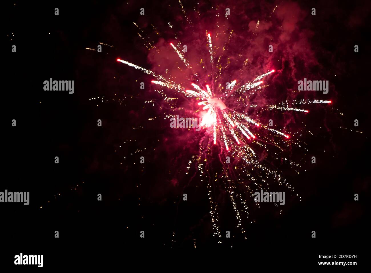 Red explosion of fireworks with smoke and bokeh on a black background ...